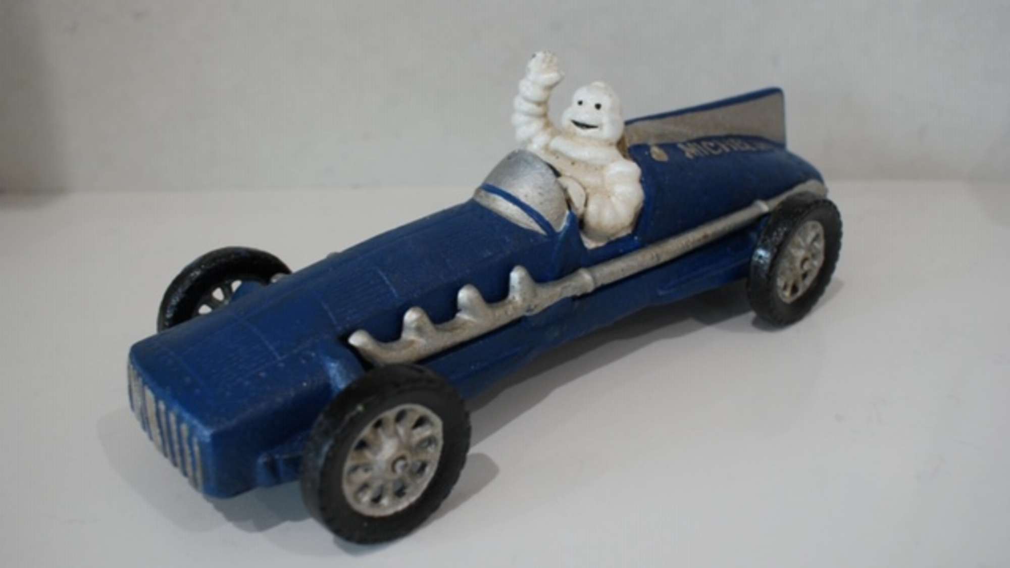 Iconic Auctioneers | 'Michelin Man' race car figure.-Sold